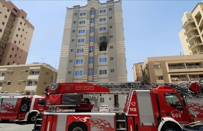Firefighters control a blaze in an apartment in the Salmiya building ...